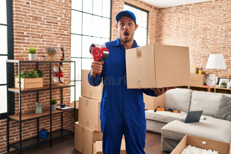 Young Hispanic Man Working on Moving Service in Shock Face, Looking ...