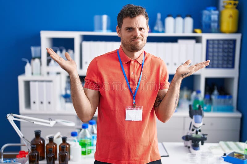 Young Hispanic Man Working at Scientist Laboratory Clueless and ...