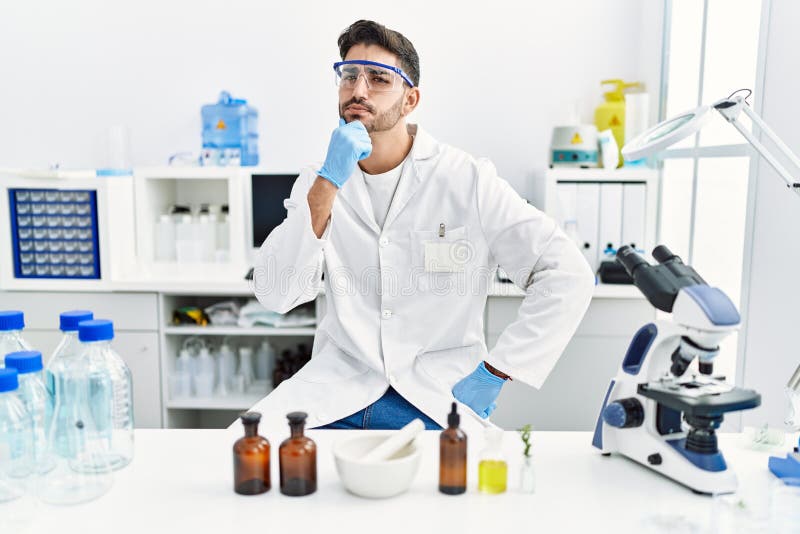 Young Hispanic Man Working at Scientist Laboratory Serious Face ...