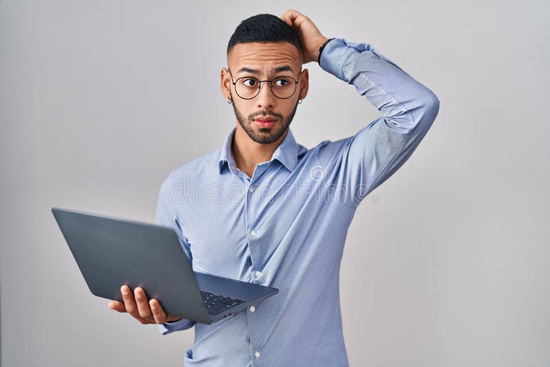Young Hispanic Man Working Using Computer Laptop Confuse and Wondering ...