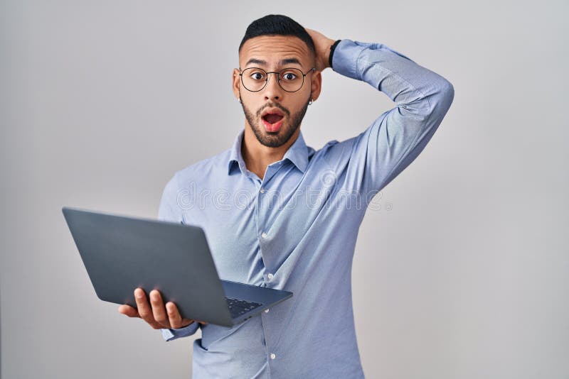 Young Hispanic Man Working Using Computer Laptop Crazy and Scared with ...