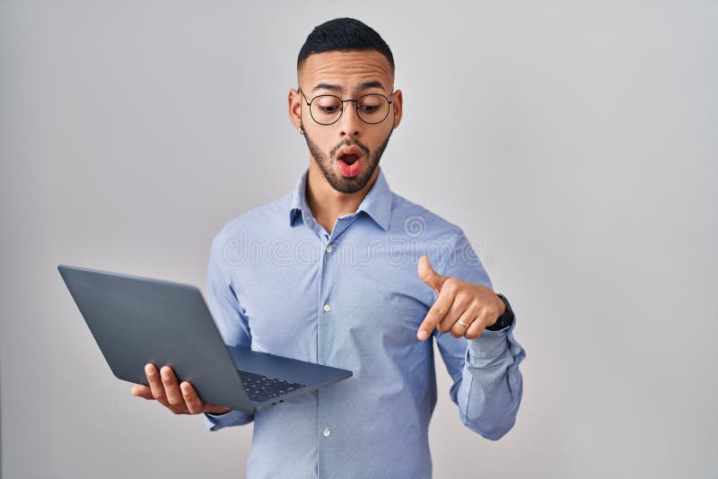 Young Hispanic Man Working Using Computer Laptop Pointing Down with Fingers Showing ...