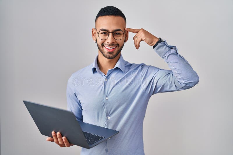 Young Hispanic Man Working Using Computer Laptop Smiling Pointing To ...