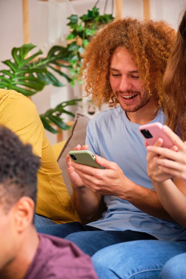 Young Hispanic Man Using His Smartphone Sitting with Friends. Stock ...