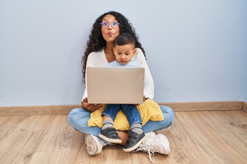 Young Hispanic Mother and Kid Using Computer Laptop Sitting on the ...