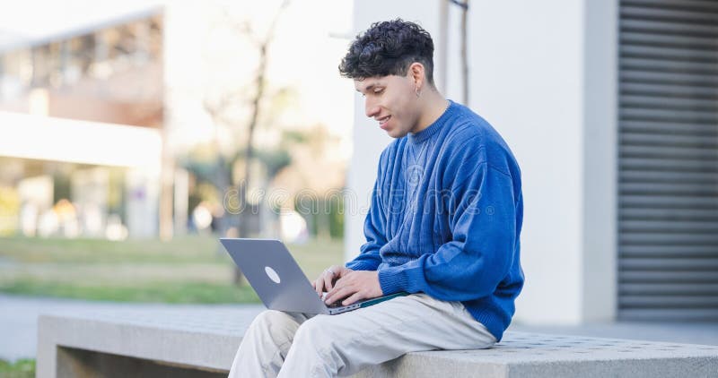Young Hispanic Student Working on Laptop Sitting on Bench in University ...