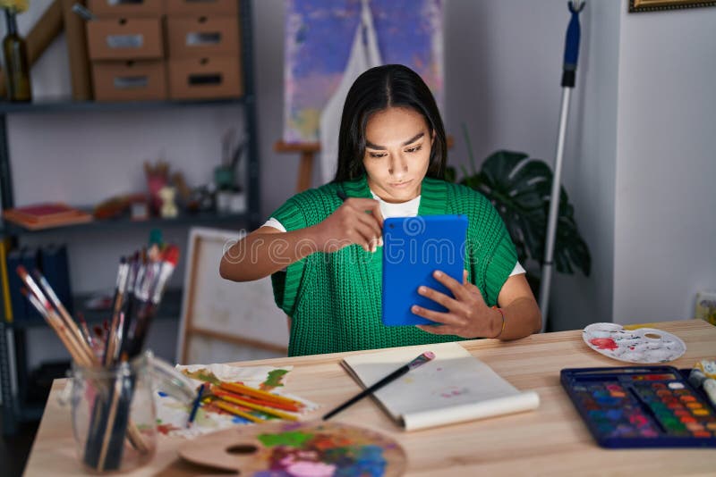 Young Hispanic Woman Artist Drawing on Touchpad at Art Studio Stock ...