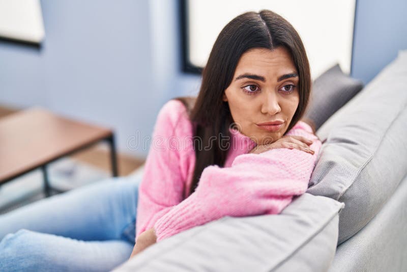 Young Hispanic Woman with Boring Expression Sitting on Sofa at Home ...