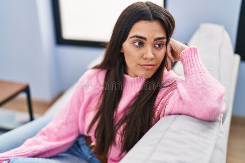 Young Hispanic Woman with Boring Expression Sitting on Sofa at Home ...