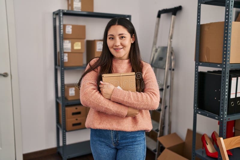Young Hispanic Woman Ecommerce Business Worker Hugging Package at ...
