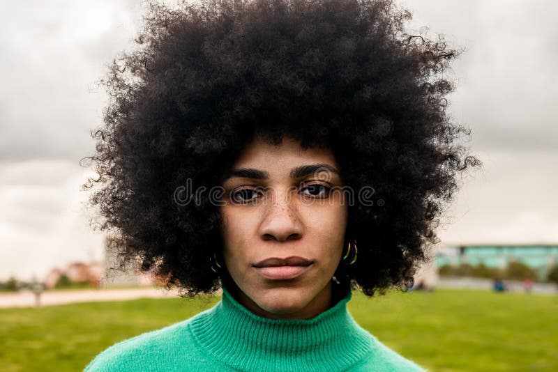 Young Hispanic Woman Looking in Front of a Camera in Park Stock Photo ...