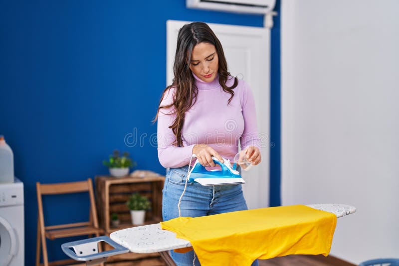 Young Hispanic Woman Pouring Water on Iron Machine at Laundry Room ...