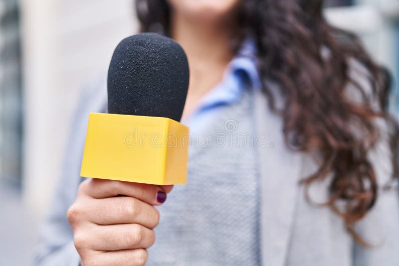 Young Hispanic Woman Reporter Working Using Microphone at Street Stock ...