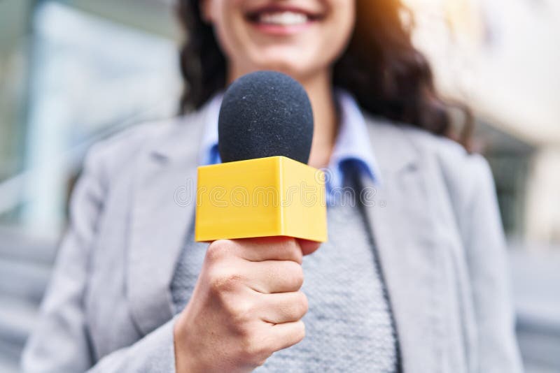 Young Hispanic Woman Reporter Working Using Microphone at Street Stock ...