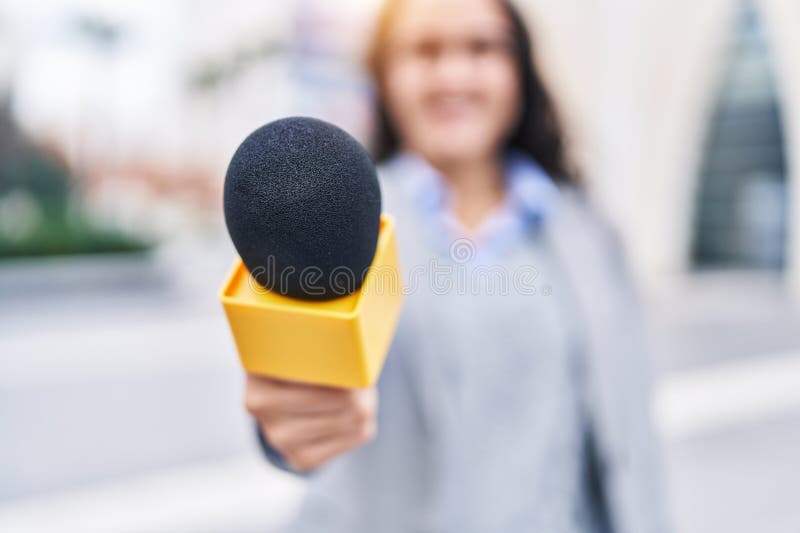Young Hispanic Woman Reporter Working Using Microphone at Street Stock ...