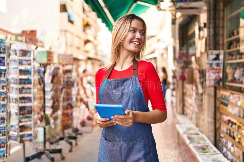 Young Hispanic Woman Shop Assistant Using Touchpad at Street Stock ...