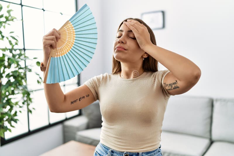 Young Hispanic Woman Smiling Confident Using Hand Fan at Home Stock ...
