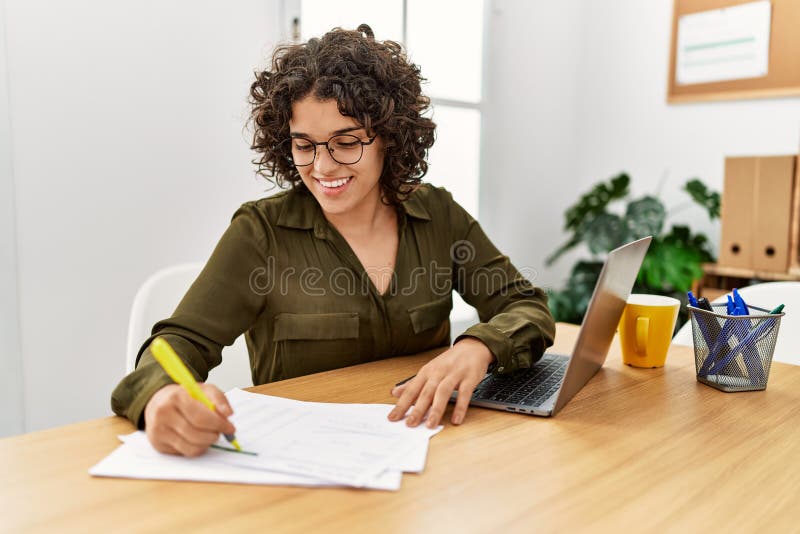 Young Hispanic Woman Smiling Confident Writing on Document at Office ...