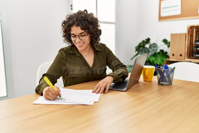 Young Hispanic Woman Smiling Confident Writing on Document at Office ...