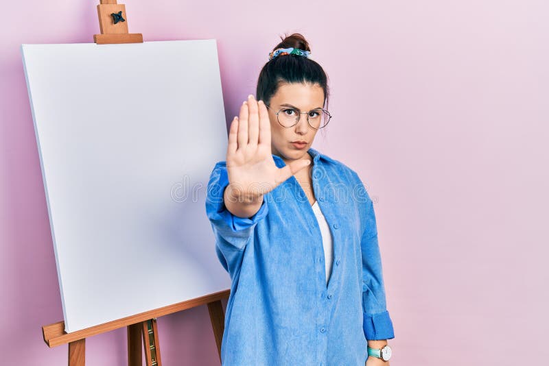Young Hispanic Woman Standing by Painter Easel Stand Doing Stop Sing ...