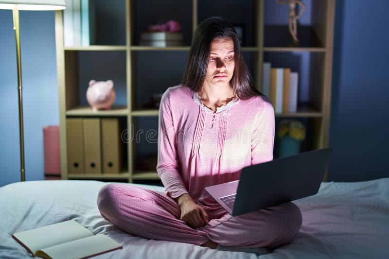 Young Hispanic Woman Using Computer Laptop on the Bed Depressed and ...