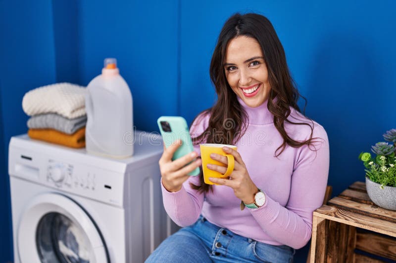 Young Hispanic Woman Using Smartphone and Drinking Coffee Waiting for ...