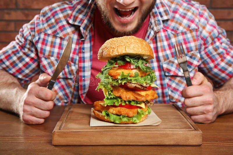 Young Hungry Man with Cutlery and Tasty Huge Burger Stock Photo - Image ... Young Hungry Man with Cutlery and Tasty Huge Burger Stock Photo - Image ...