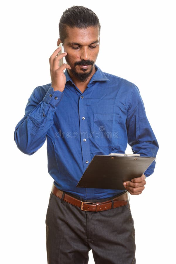 Young Indian Businessman Talking on Mobile Phone while Holding C Stock ... Young Indian Businessman Talking on Mobile Phone while Holding C Stock ...