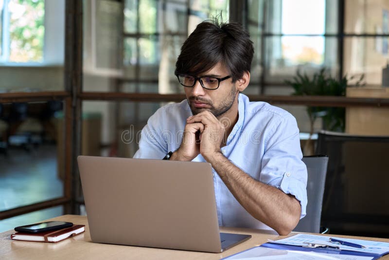 Young Indian Business Man Watching Business Webinar on Laptop in Office ...