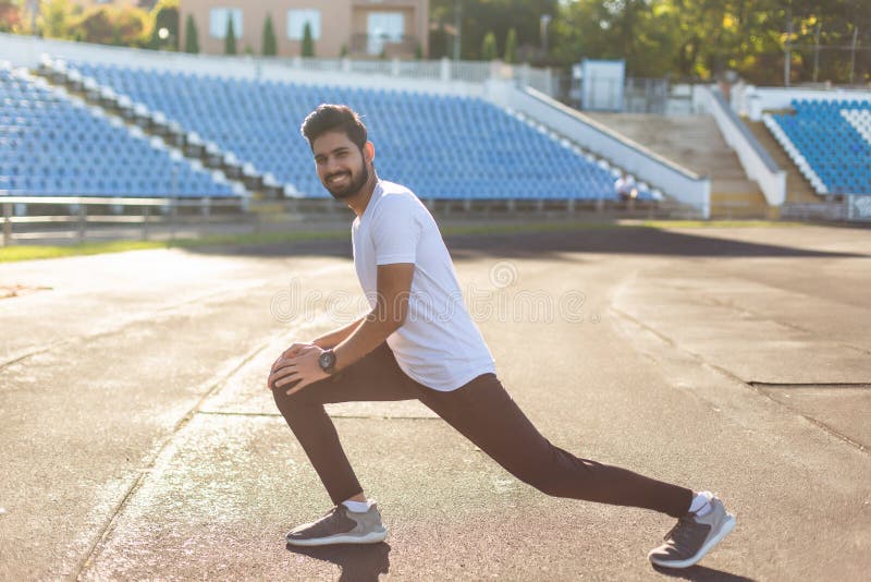 Young Indian Man Doing Stretching Exercise on Running Track Stock Photo ...