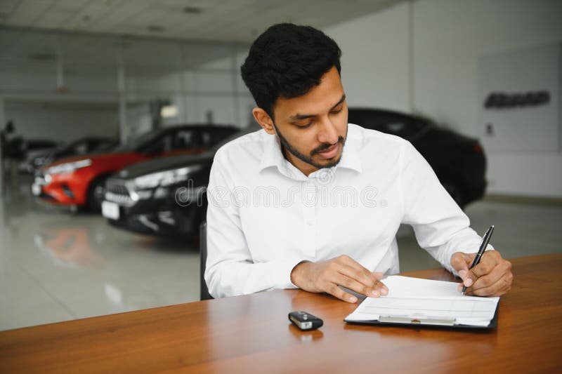 Young Indian Man Signing Documents at Car Dealership Stock Image ...