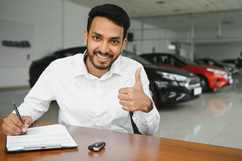 Young Indian Man Signing Documents at Car Dealership Stock Photo ...