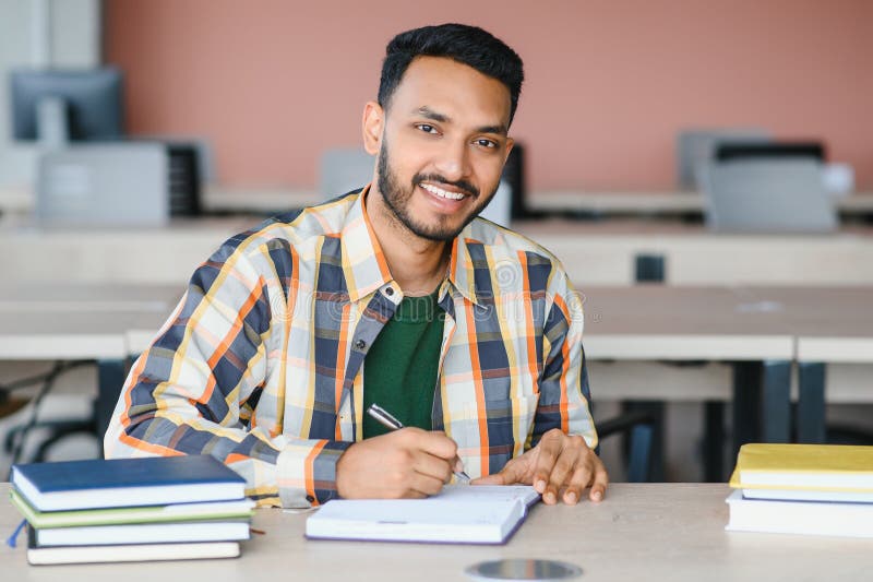 Young Indian Student Boy Reading Book Studying in College Library with ...