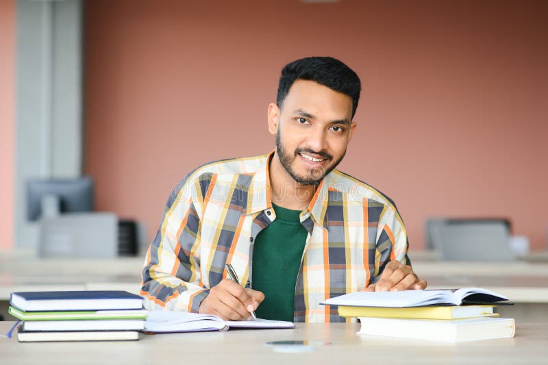 Young Indian Student Boy Reading Book Studying in College Library with ...