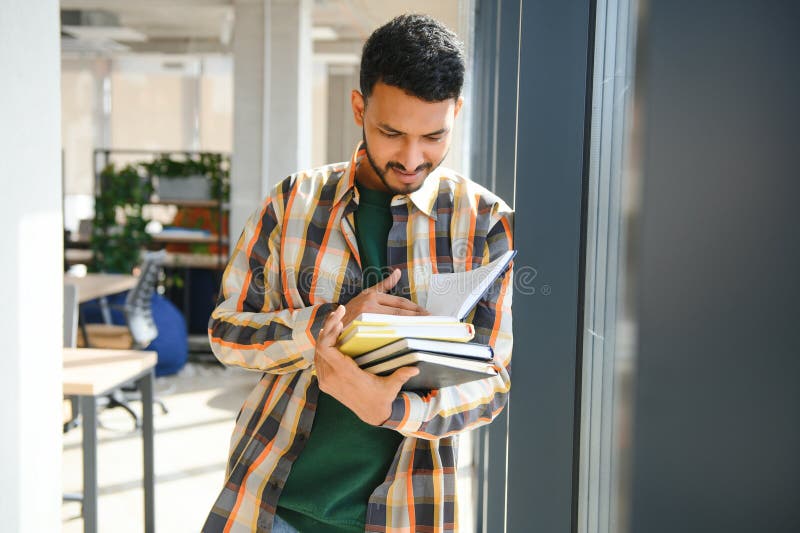 Young Indian Student Boy Reading Book Studying in College Library with ...