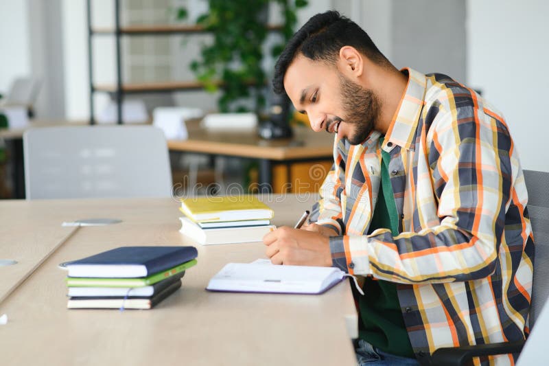 Young Indian Student Boy Reading Book Studying in College Library with ...