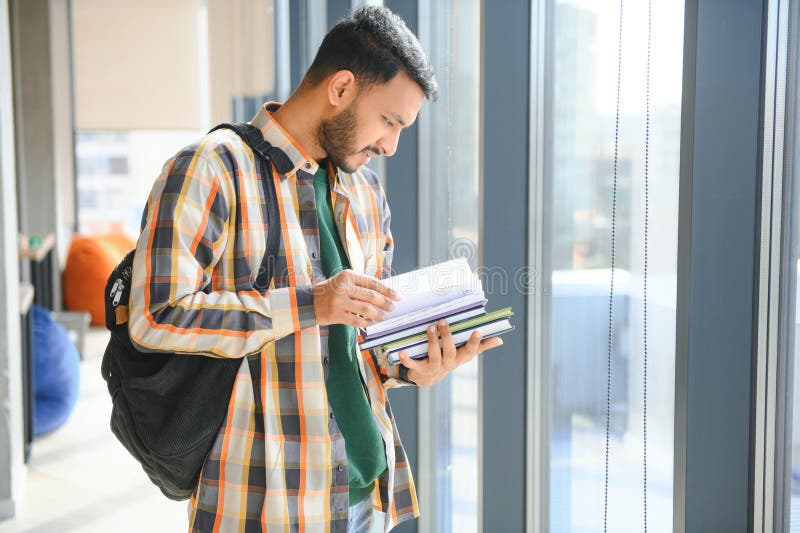 Young Indian Student Boy Reading Book Studying in College Library with ...