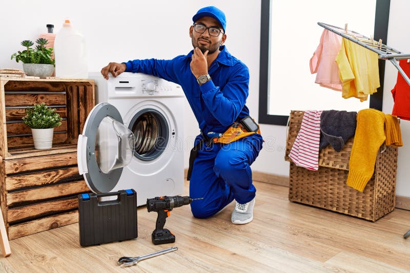 Young Indian Technician Working on Washing Machine with Hand on Chin ...