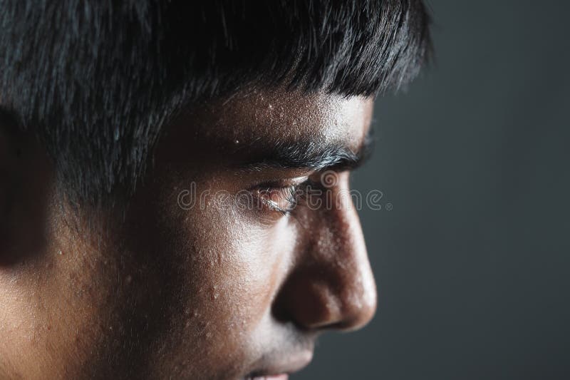 Young Person in Profile with Focused Expression and Subtle Lighting ...