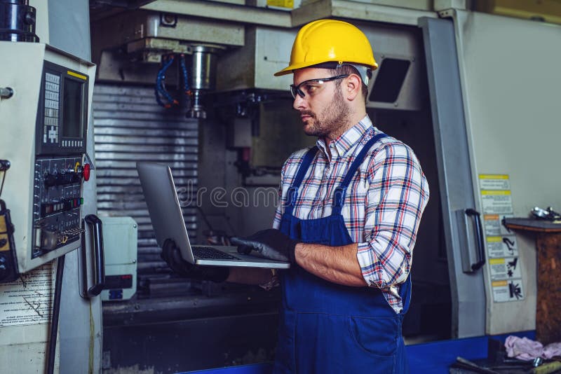 Industry Worker Entering Data in CNC Machine at Factory. Stock Image ...