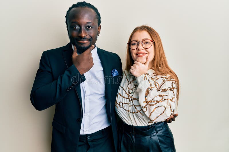 Young Interracial Couple Wearing Business And Elegant Clothes Looking