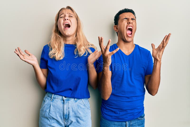 Young Interracial Couple Wearing Casual Clothes Celebrating Mad And