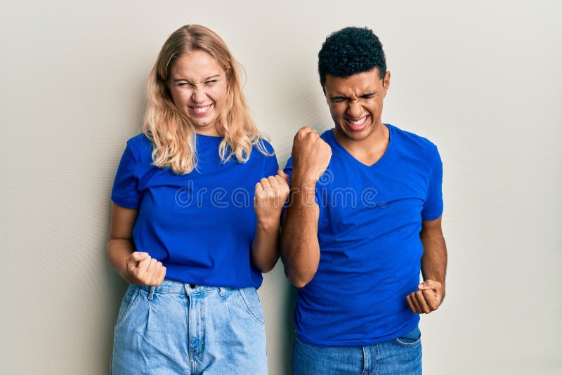 Young Interracial Couple Wearing Casual Clothes Celebrating Surprised
