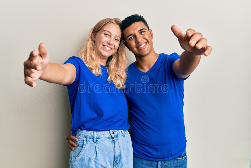Young Interracial Couple Wearing Casual Clothes Looking At The Camera