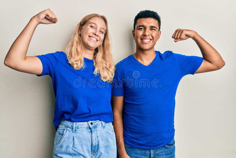Young Interracial Couple Wearing Casual Clothes Showing Arms Muscles