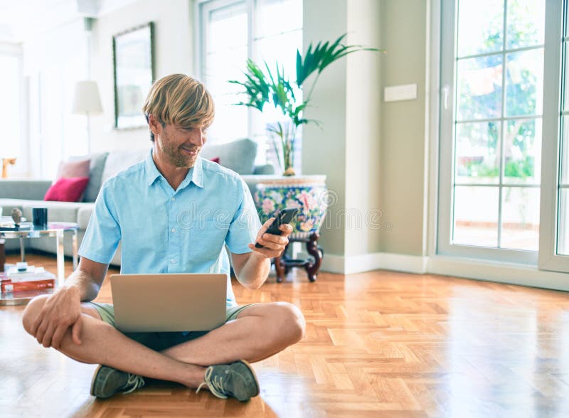 Young Irish Man Smiling Happy Working Using Laptop and Smartphone at ...