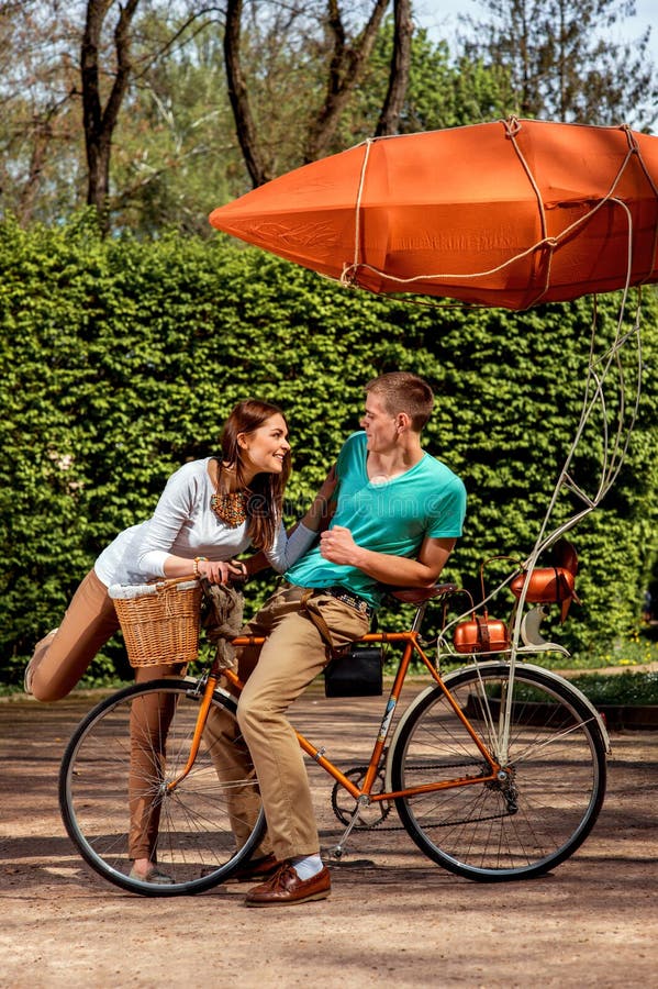 Young and Joyful Couple Having Fun in the Park with Bicycle and Stock ...