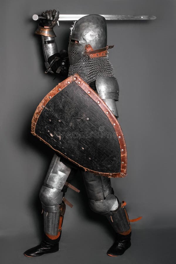 A Young Knight in Medieval Armor with a Weapon in His Hands Kneeled ...