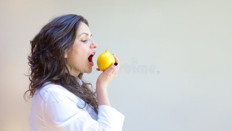A Young a Lady Bites a Lemon Stock Photo - Image of winter, body: 60922556