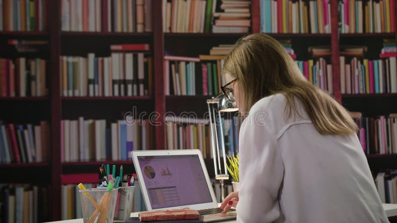 Young Lady Using a Laptop in the Library Stock Photo - Image of indoors ...
